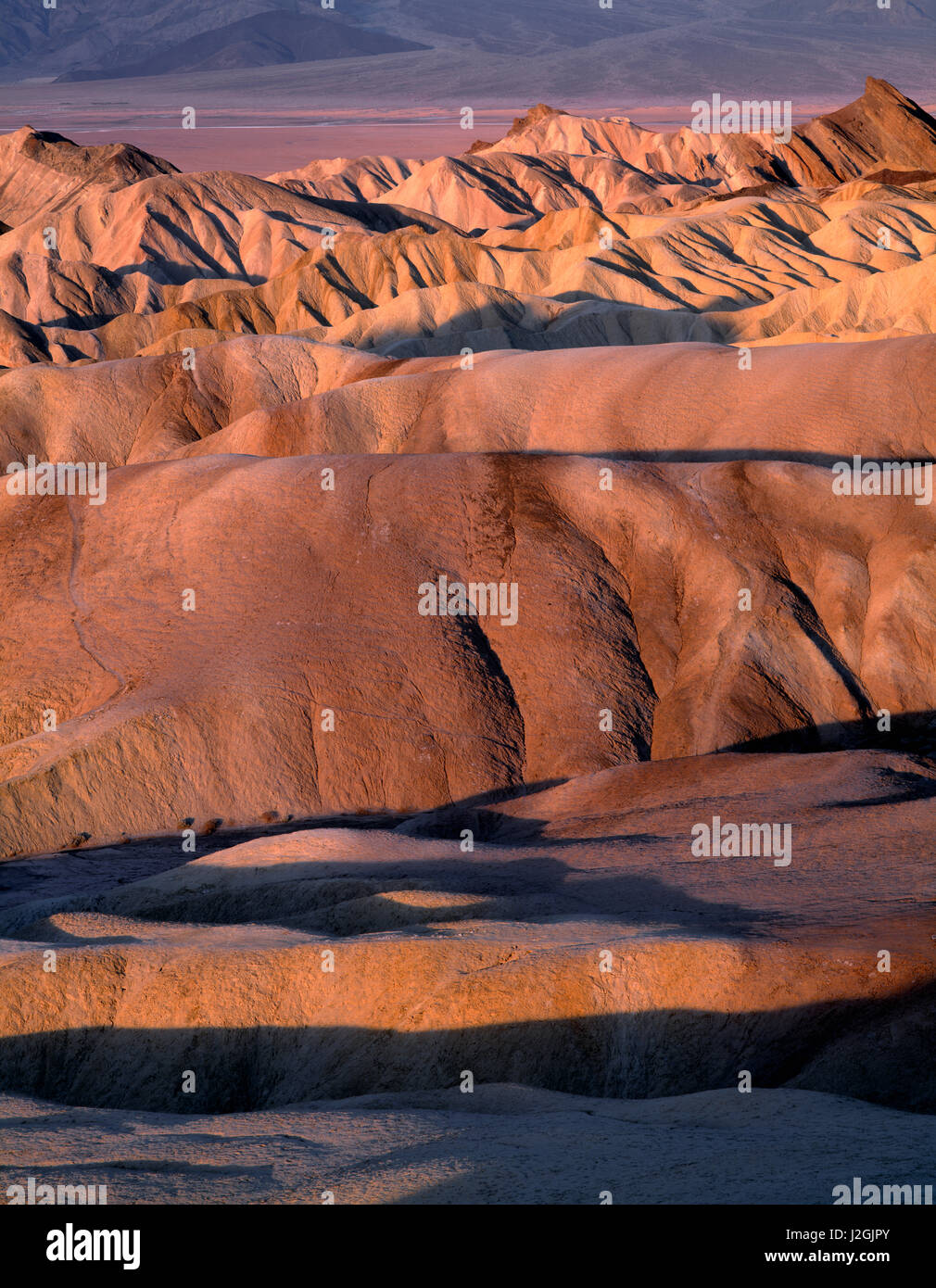USA, California, Death Valley National Park, Sunrise light on eroded ...
