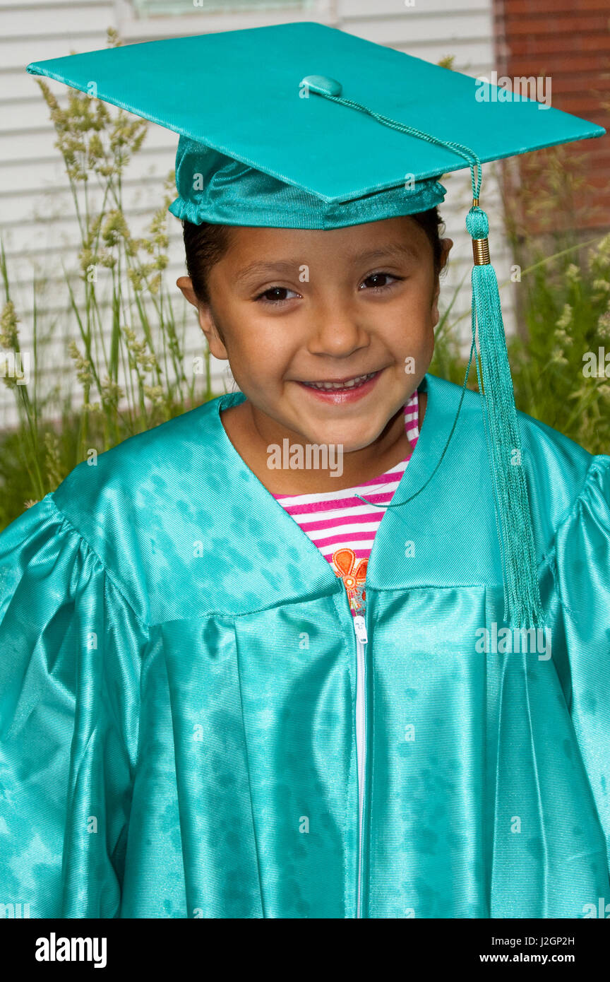 Native American child dressed in a graduation cap and gown during her ...