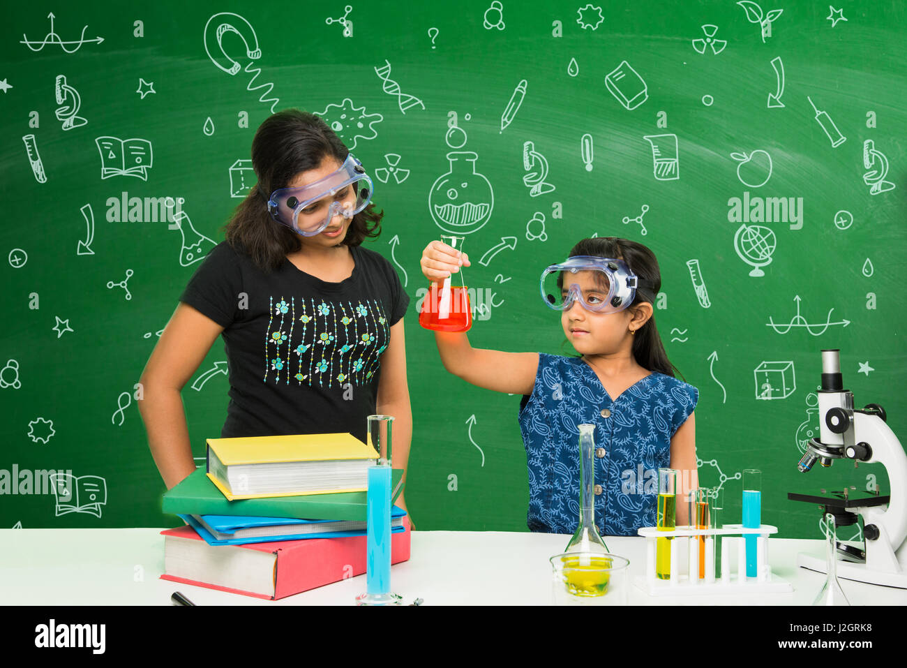 cute indian kids doing science experiment in chemistry lab or biology ...