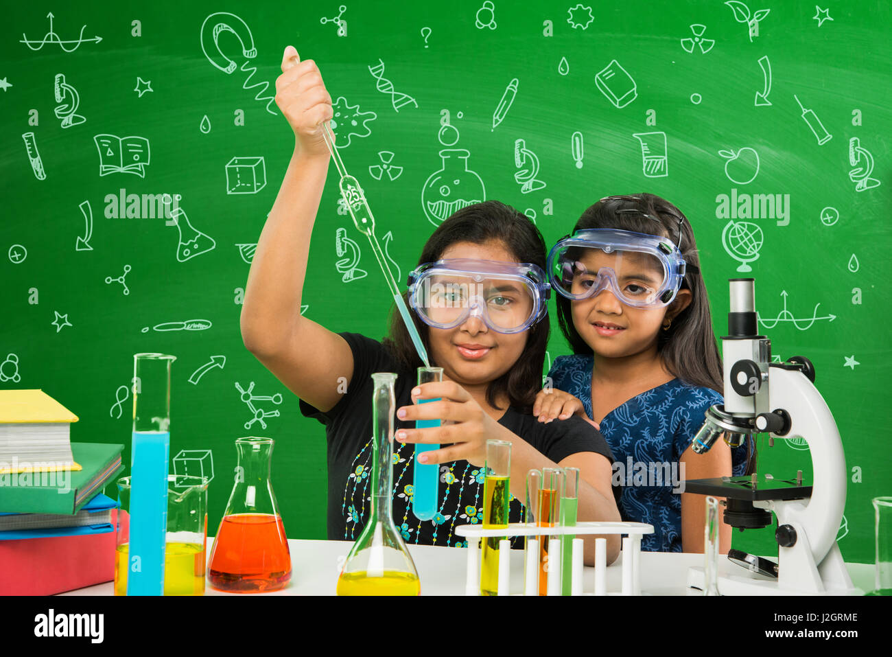 cute indian kids doing science experiment in chemistry lab or biology ...
