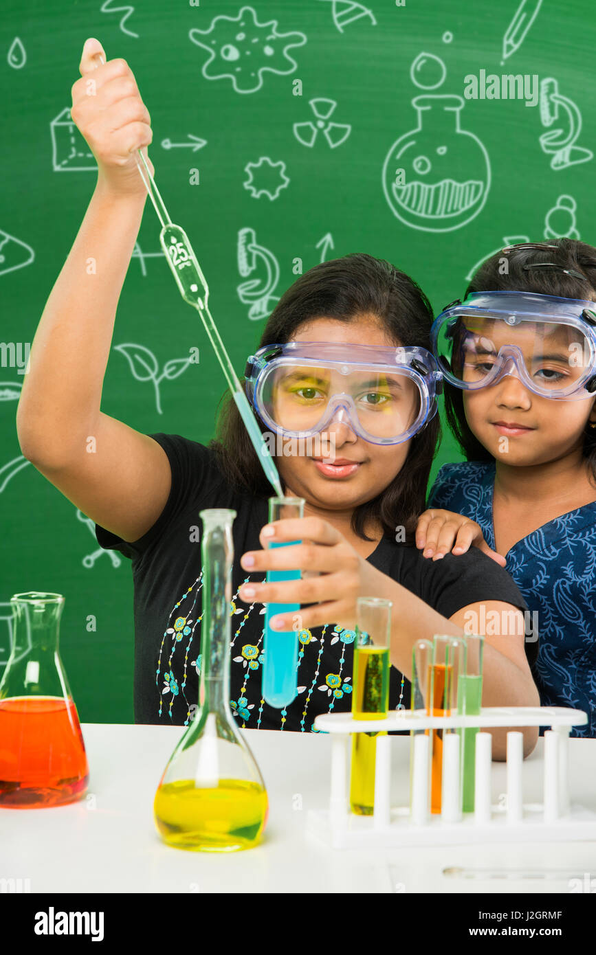 cute indian kids doing science experiment in chemistry lab or biology ...