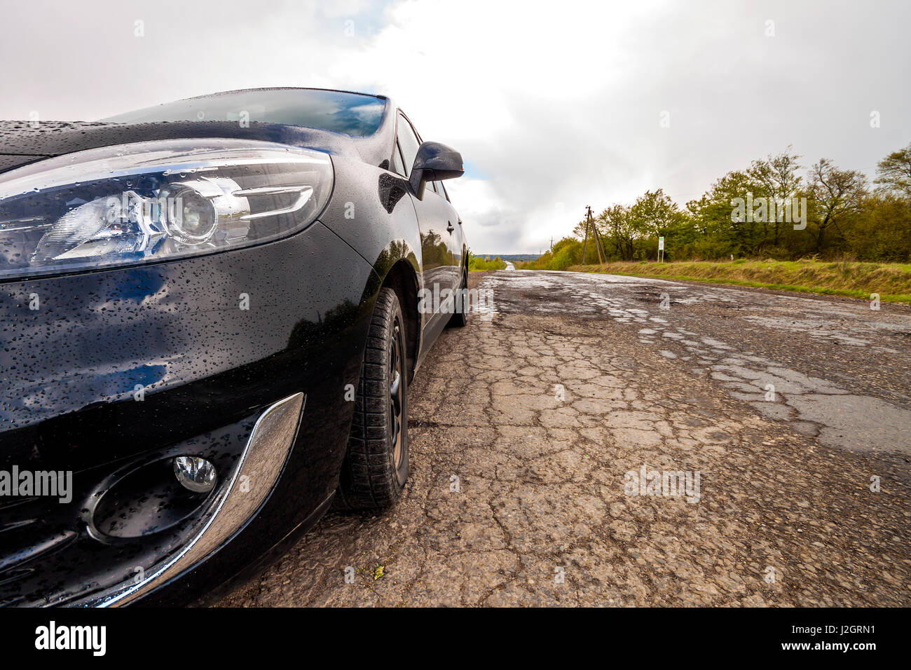 Close-up picture of a modern car on a bad road Stock Photo - Alamy