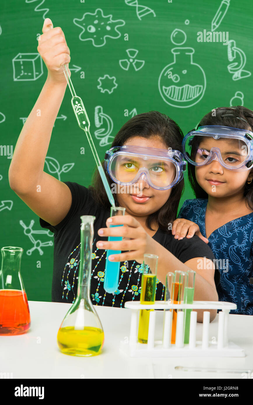 cute indian kids doing science experiment in chemistry lab or biology ...