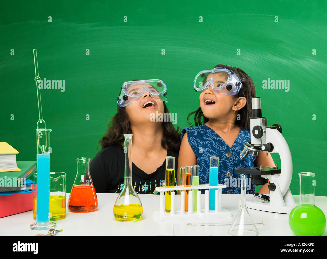 cute indian kids doing science experiment in chemistry lab or biology ...