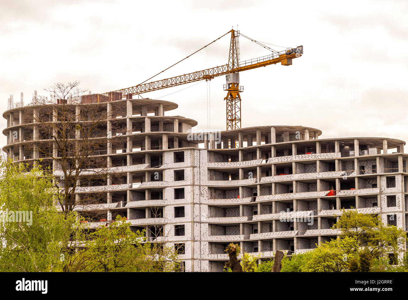 Modern building under construction against blue sky. Construction work ...