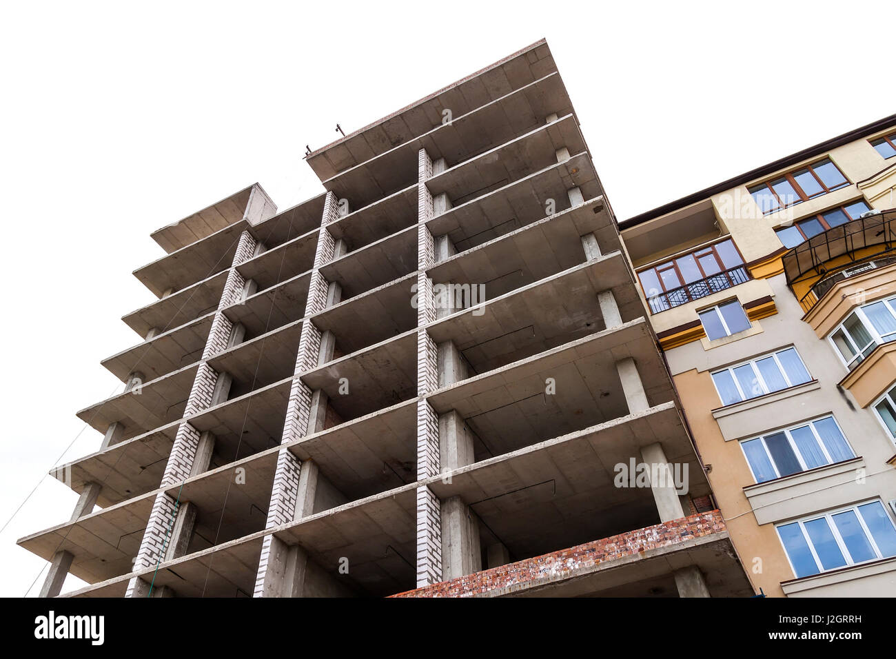 Modern building under construction against blue sky. Construction work ...
