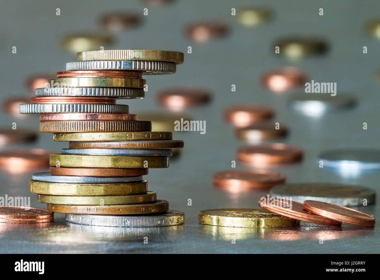 Stack of coins with blurred grey background Stock Photo - Alamy