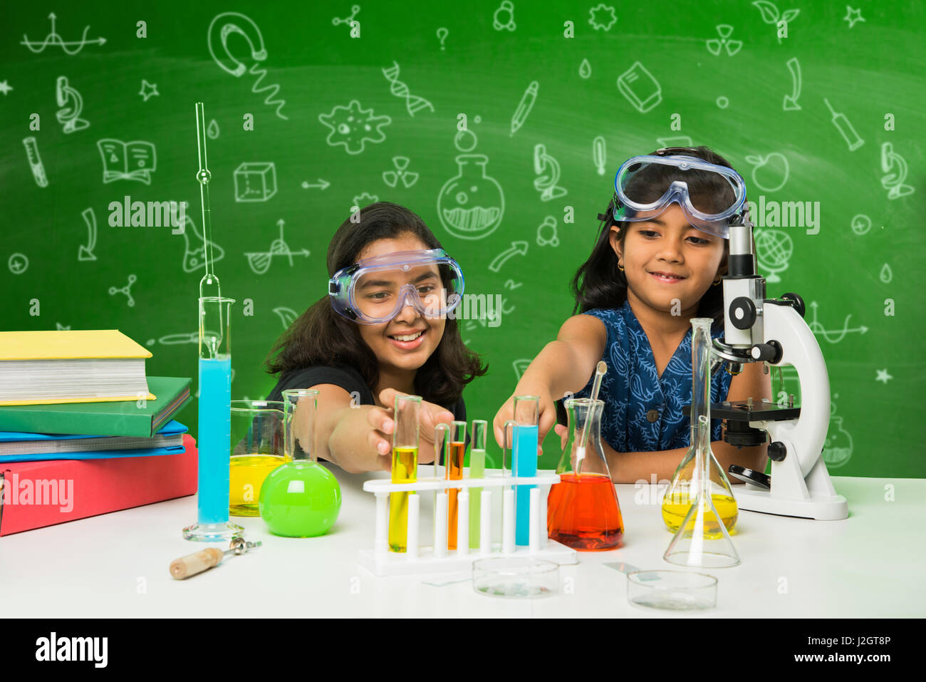 cute indian kids doing science experiment in chemistry lab or biology ...