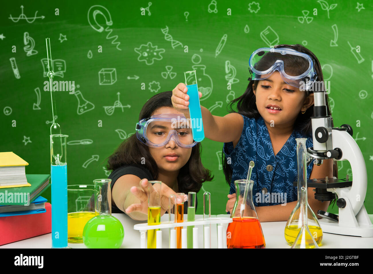 cute indian kids doing science experiment in chemistry lab or biology ...