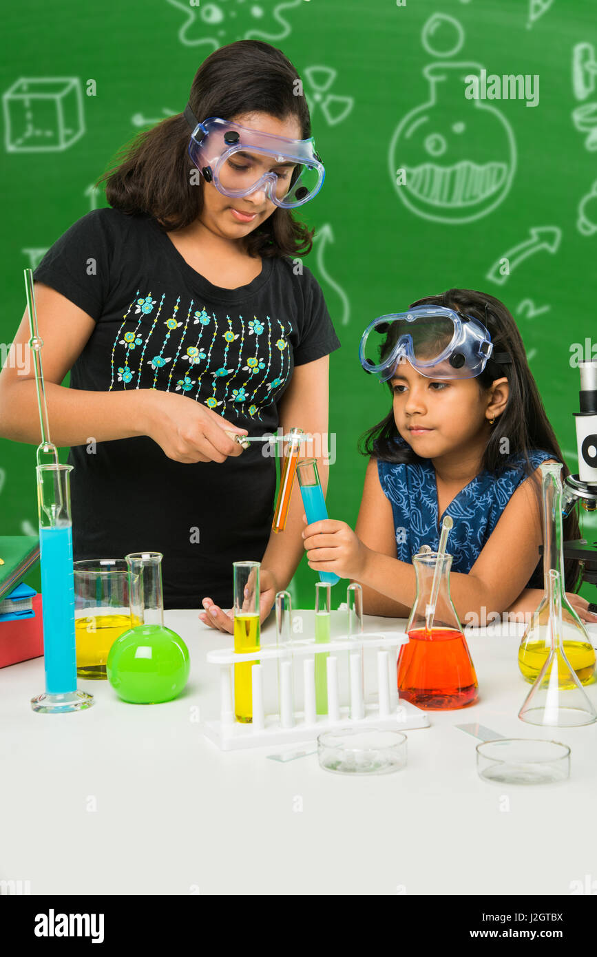 cute indian kids doing science experiment in chemistry lab or biology ...
