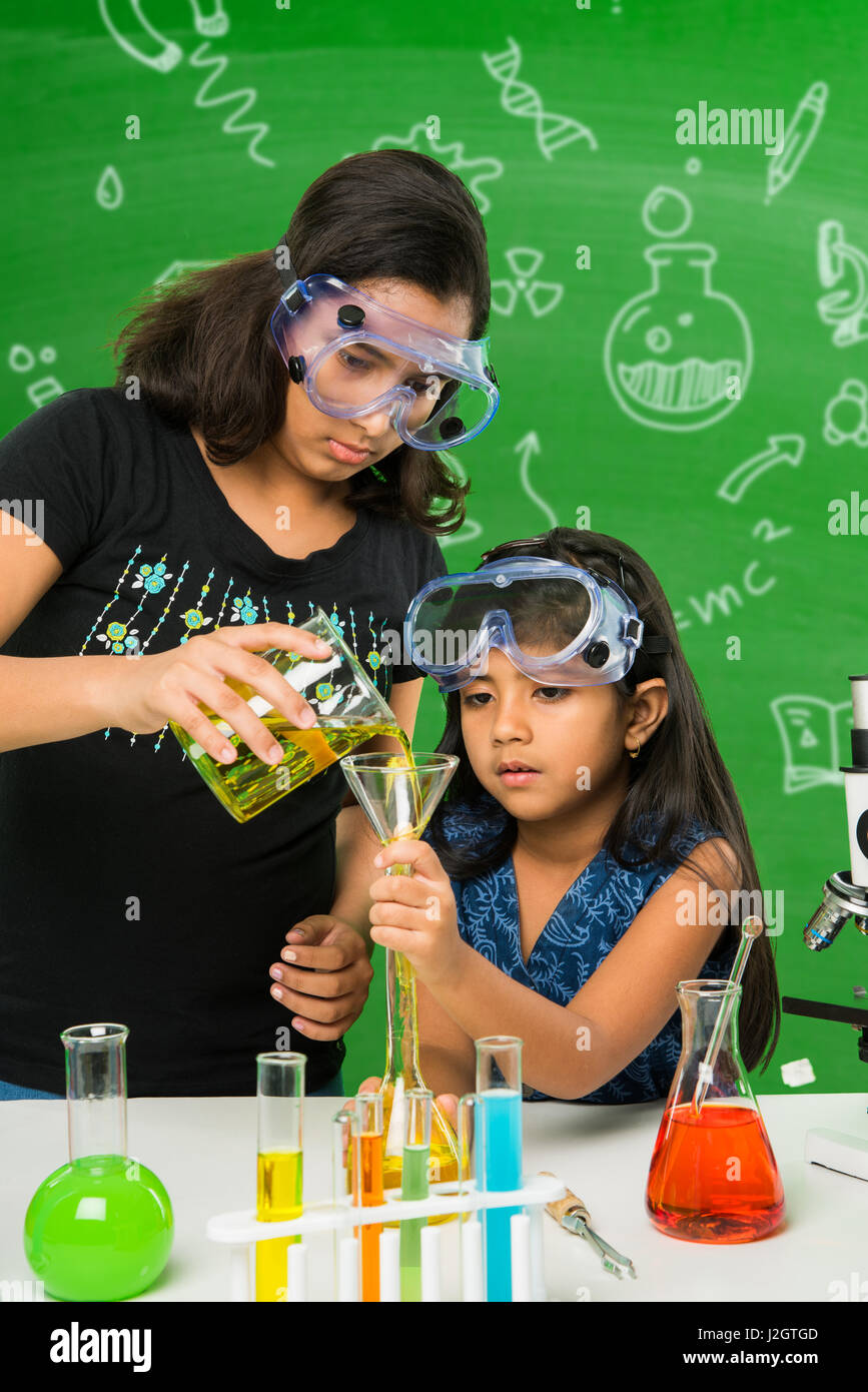 cute indian kids doing science experiment in chemistry lab or biology ...