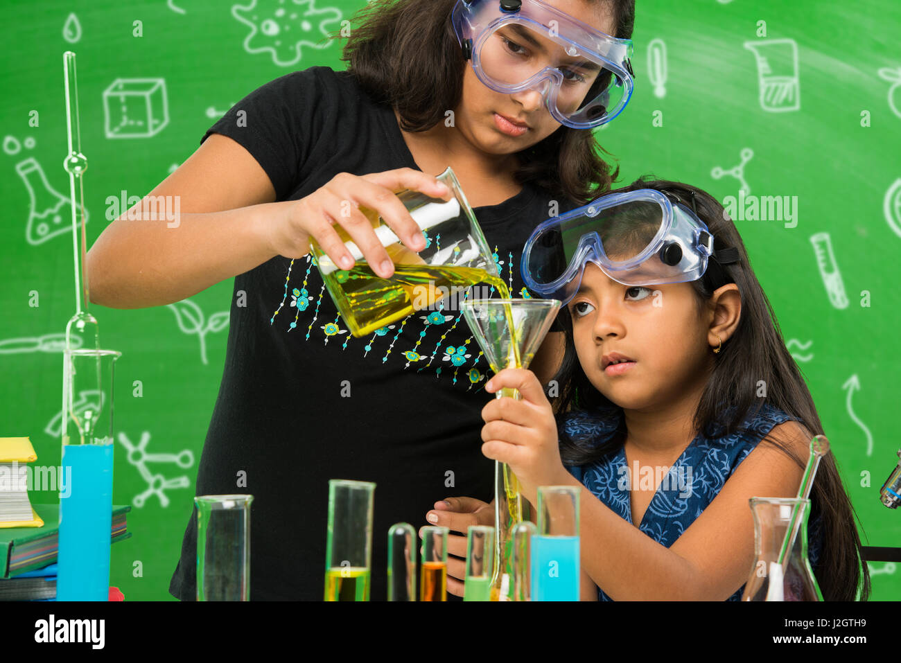 cute indian kids doing science experiment in chemistry lab or biology ...