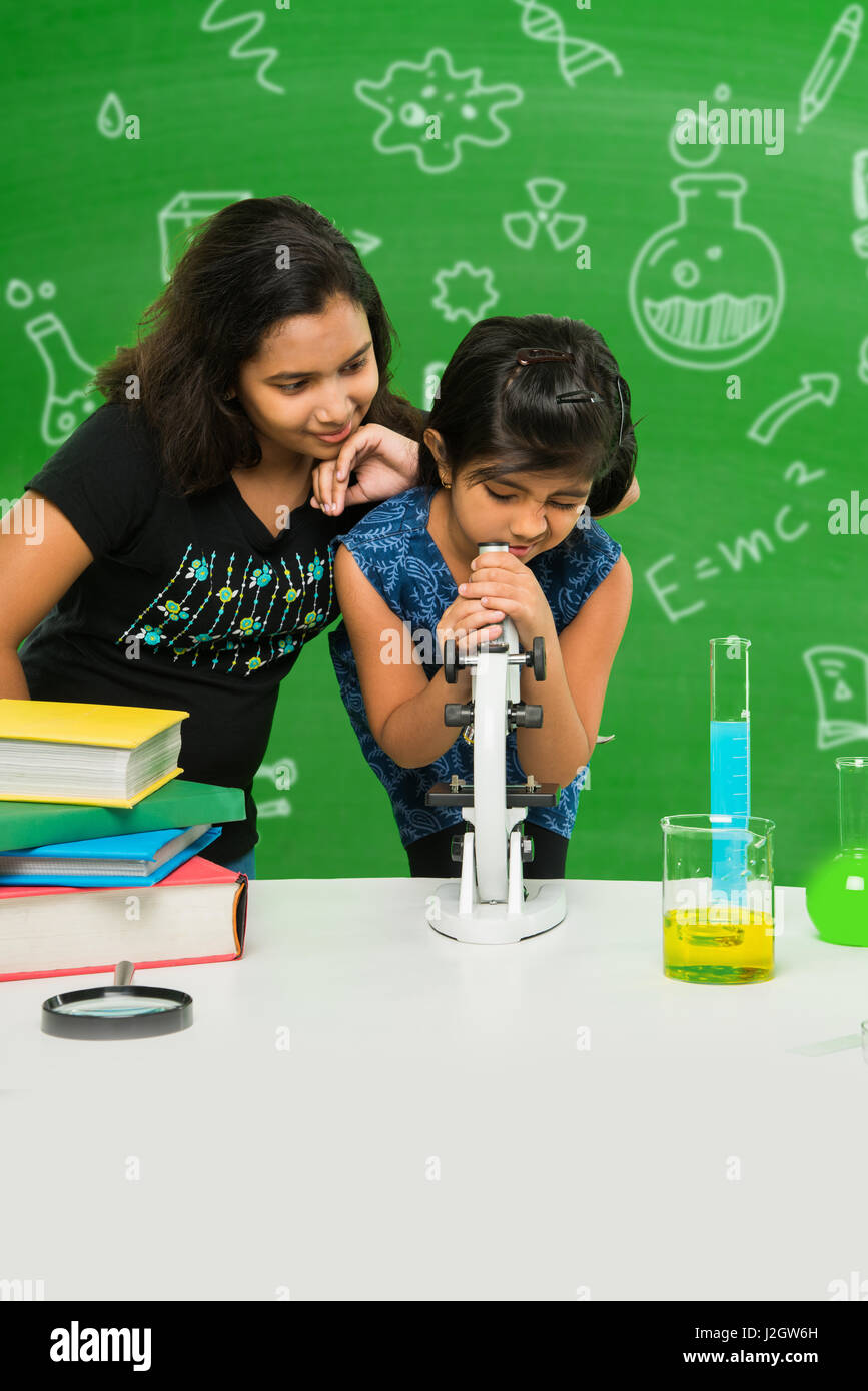 cute indian kids doing science experiment in chemistry lab or biology ...