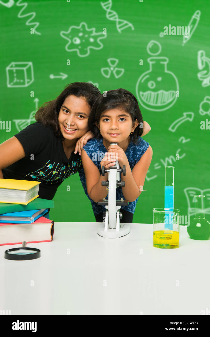 cute indian kids doing science experiment in chemistry lab or biology ...