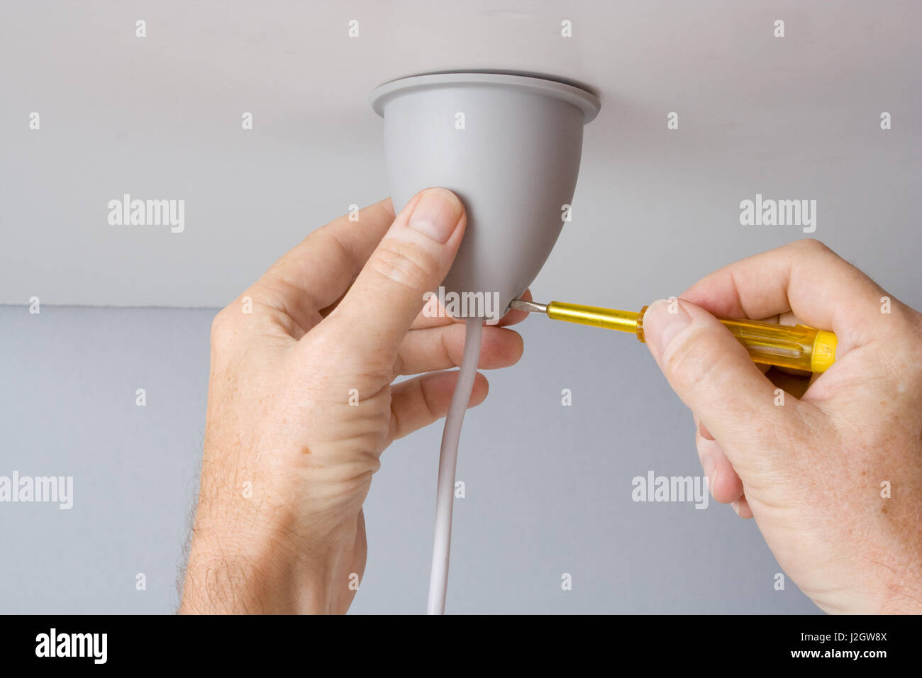 Electrician installing a light fixture on a ceiling Stock Photo - Alamy