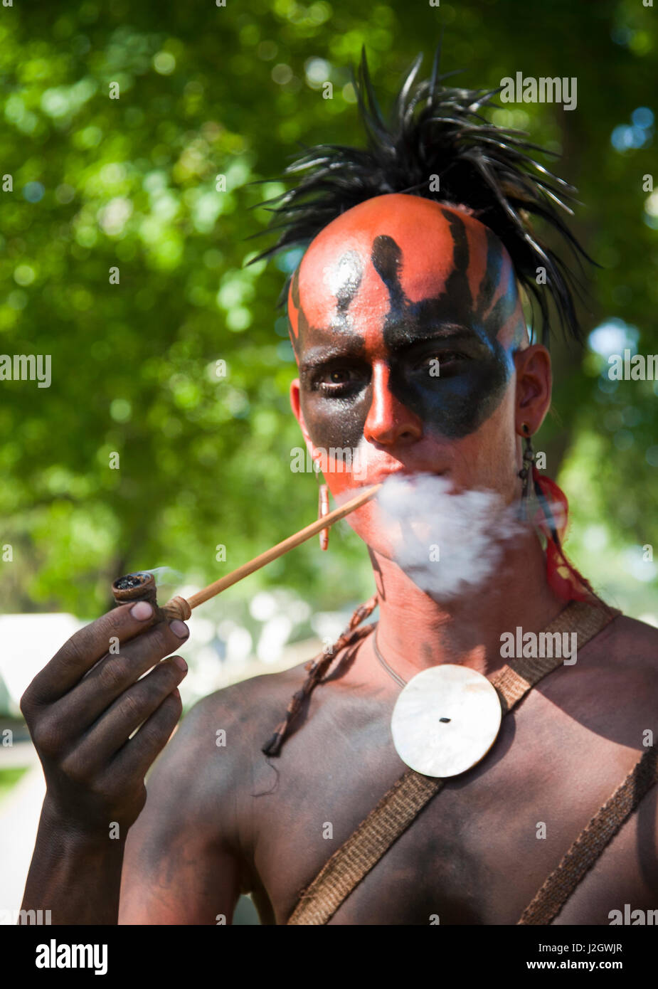 Close-up of a Native American man of the Northeastern Tribes smokes a ...