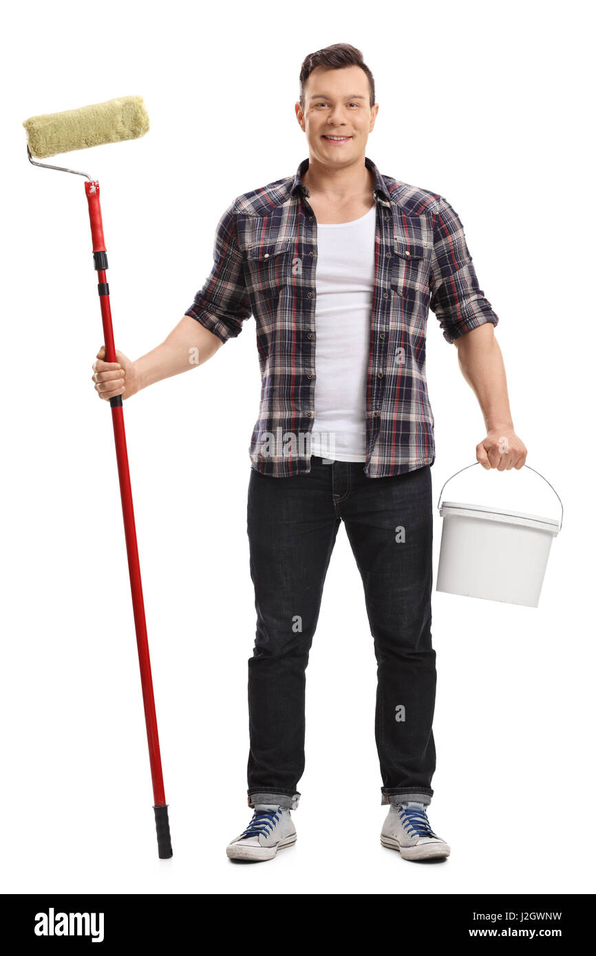 Full length portrait of a young man holding a paint roller and a color ...