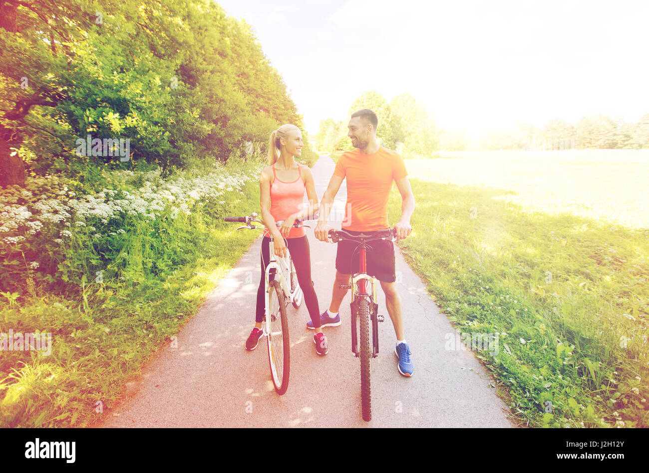 happy couple riding bicycle outdoors Stock Photo - Alamy