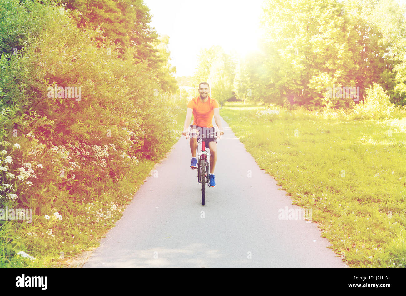 happy young man riding bicycle outdoors Stock Photo - Alamy
