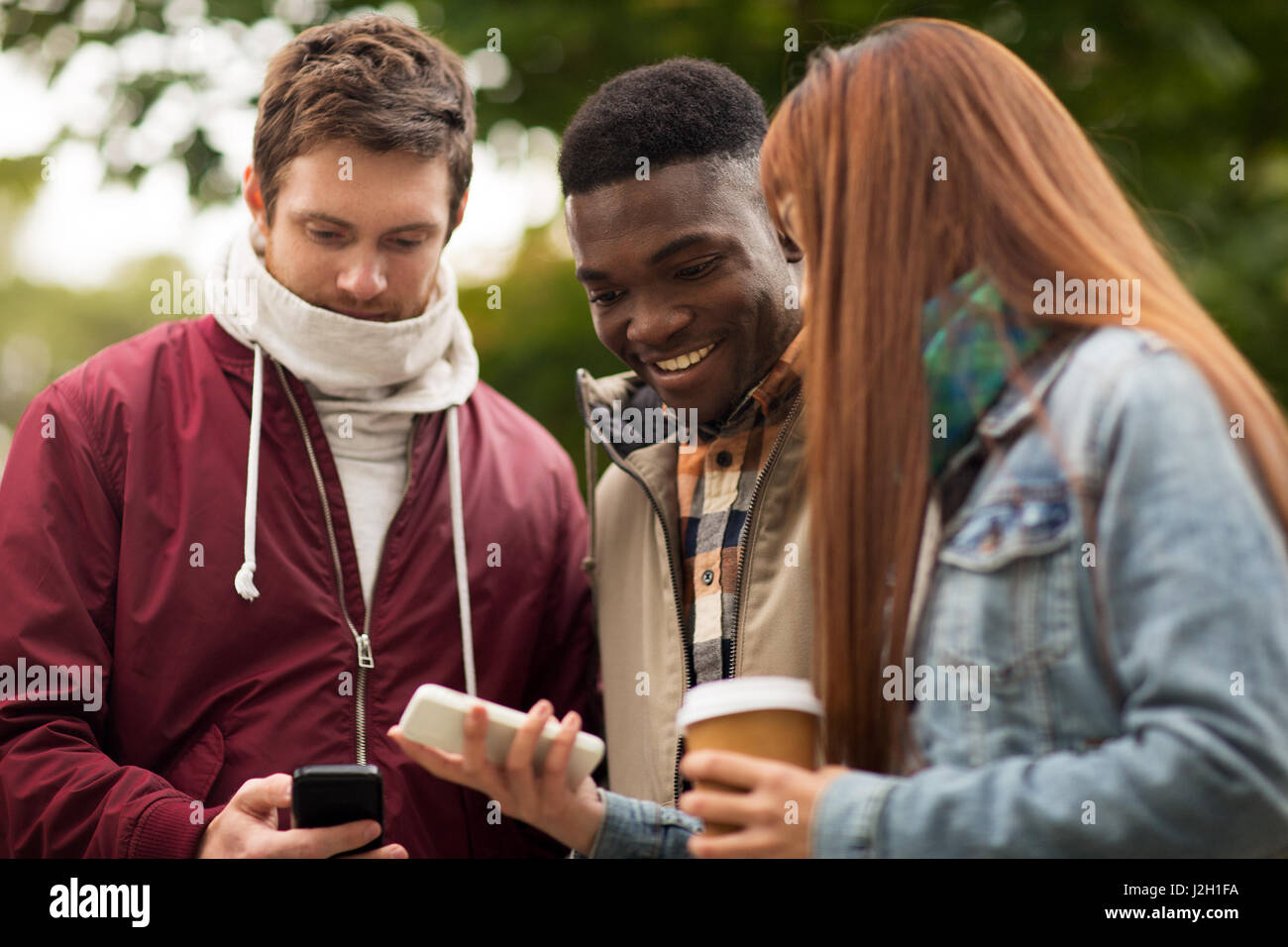 happy friends with smartphone and coffee outdoors Stock Photo - Alamy