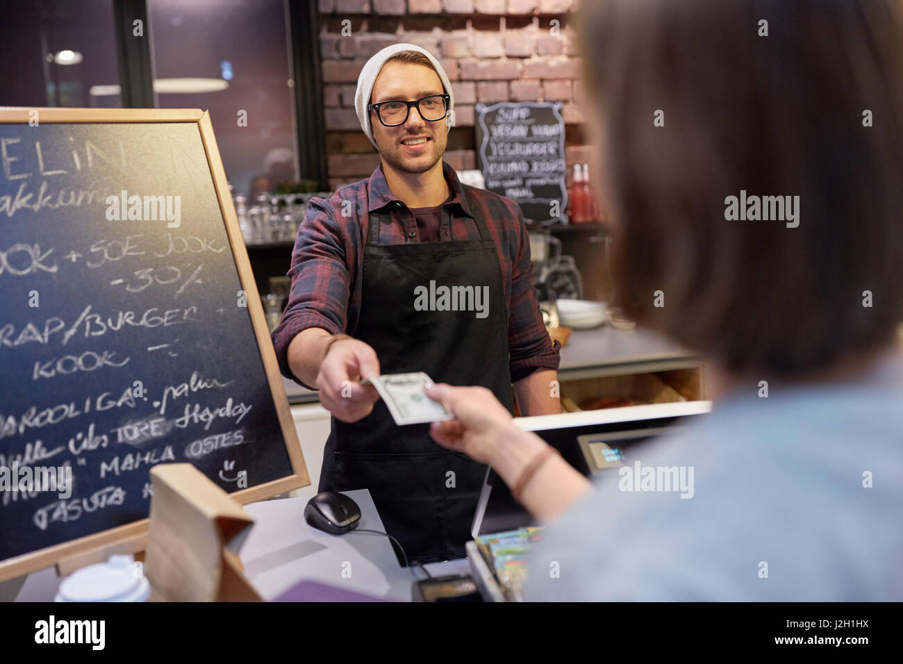 happy barman and woman paying money at cafe Stock Photo - Alamy