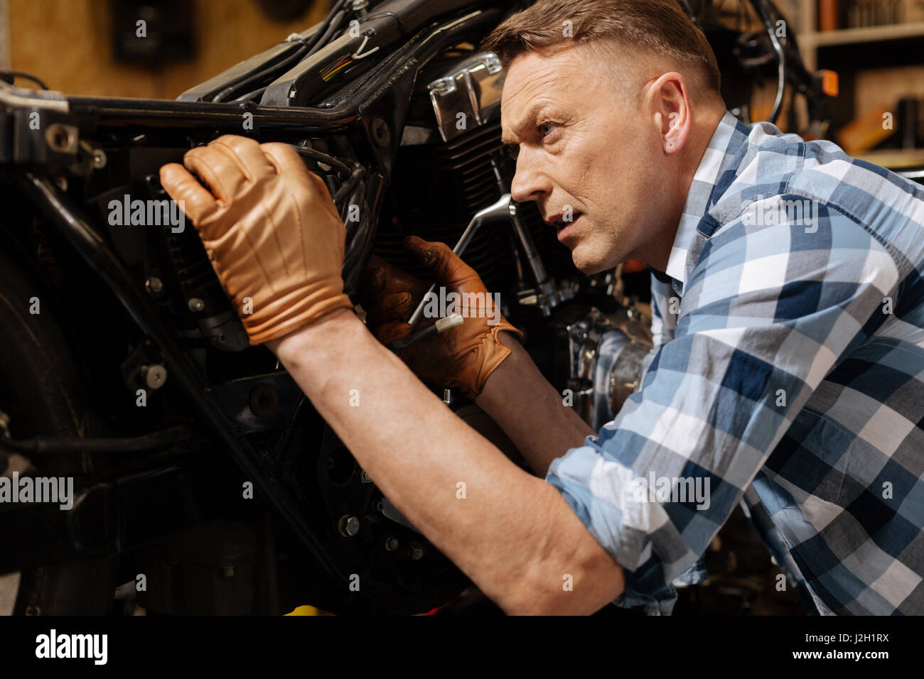 Skilled local professional fixing the engine Stock Photo - Alamy