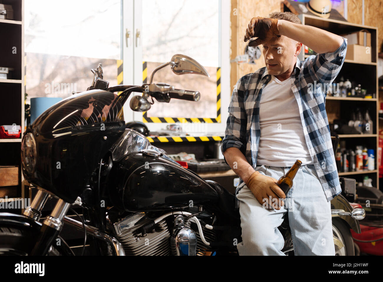 Delighted skillful mechanic tired after long a day Stock Photo - Alamy