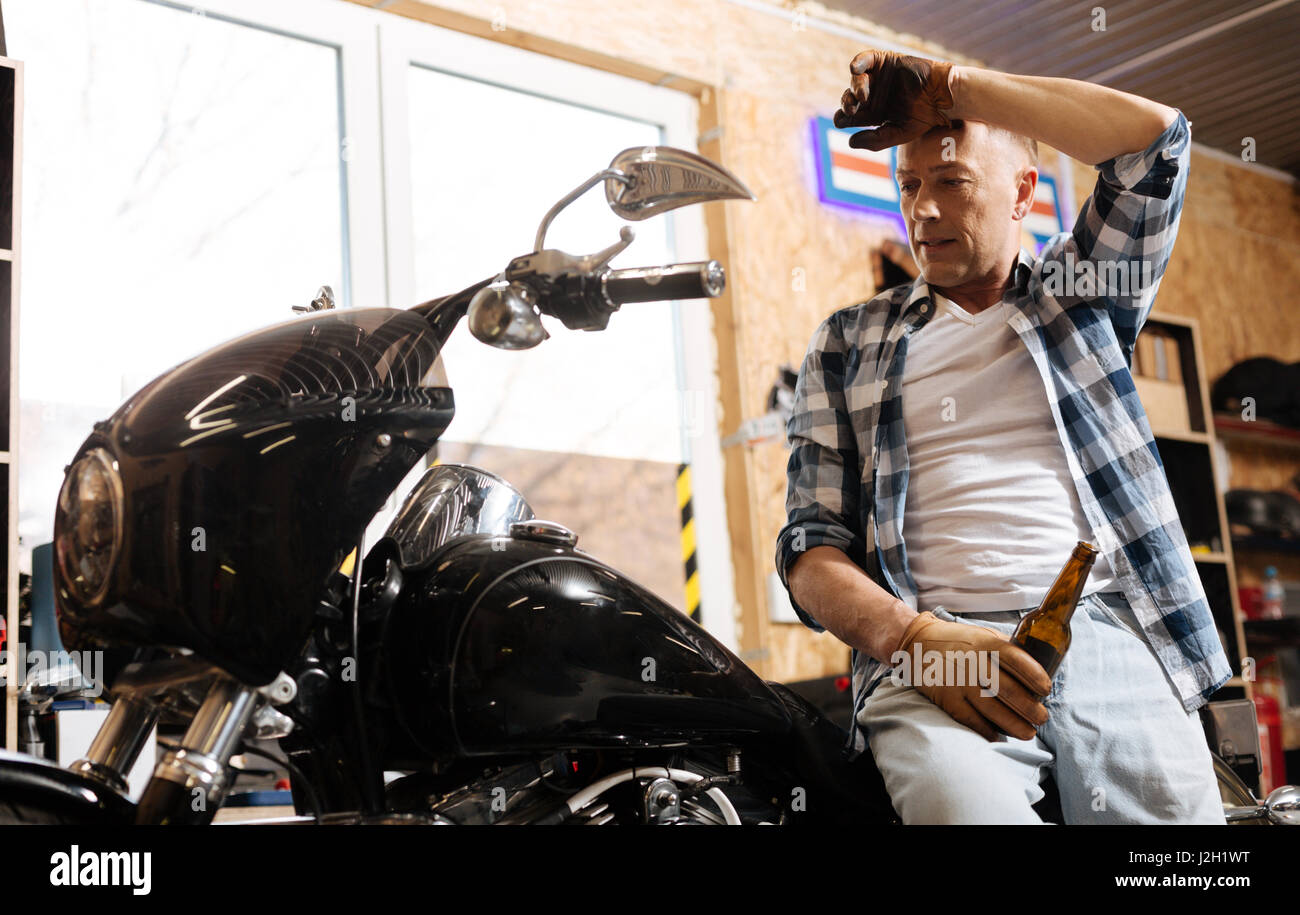 Talented weary man observing result of his work Stock Photo - Alamy