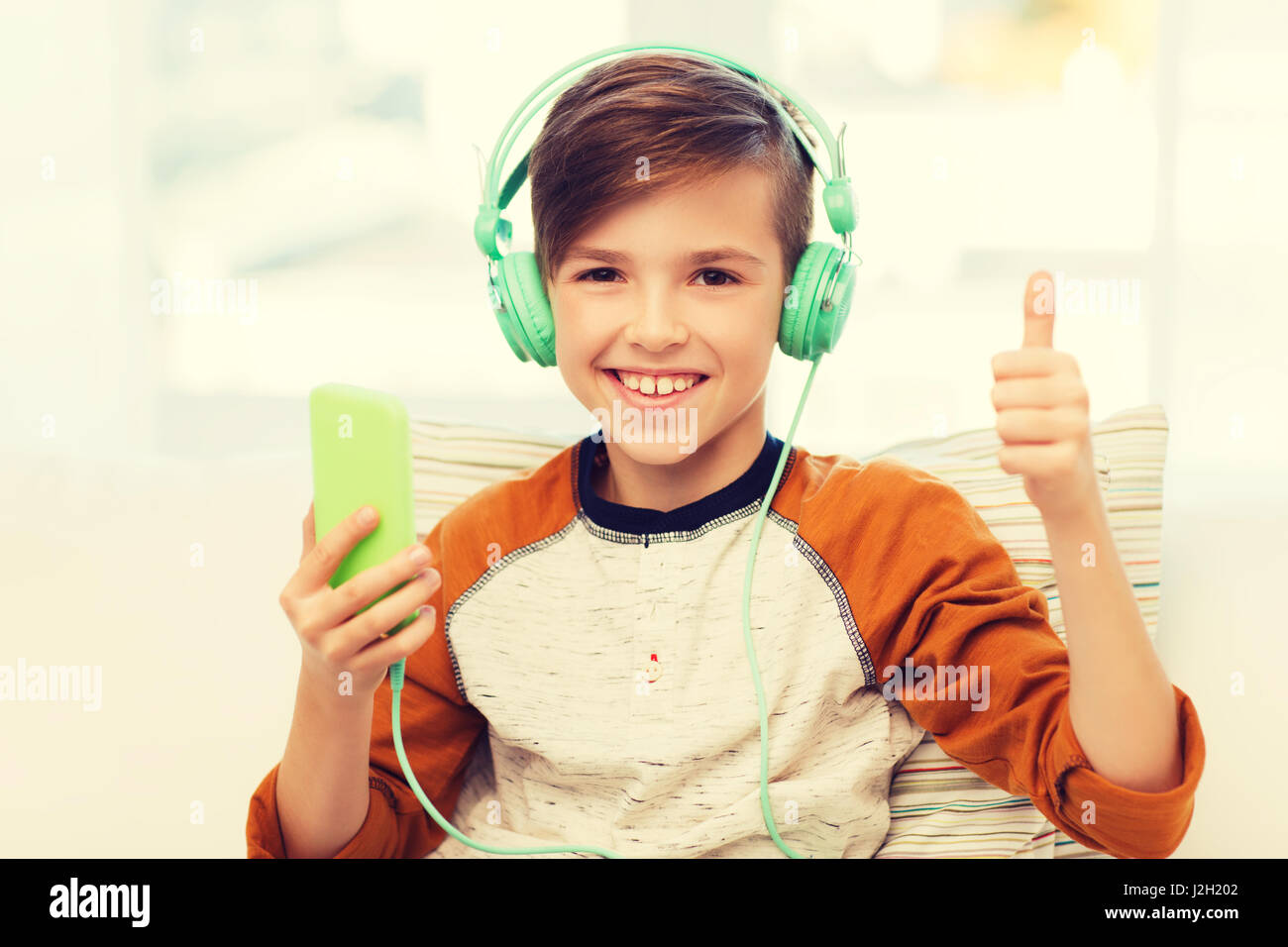 happy boy with smartphone and headphones at home Stock Photo - Alamy