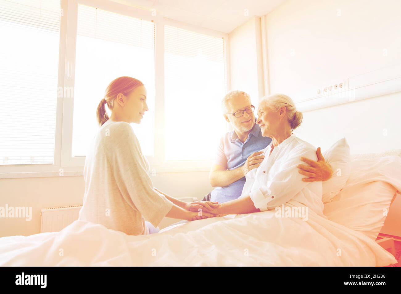 happy family visiting senior woman at hospital Stock Photo - Alamy