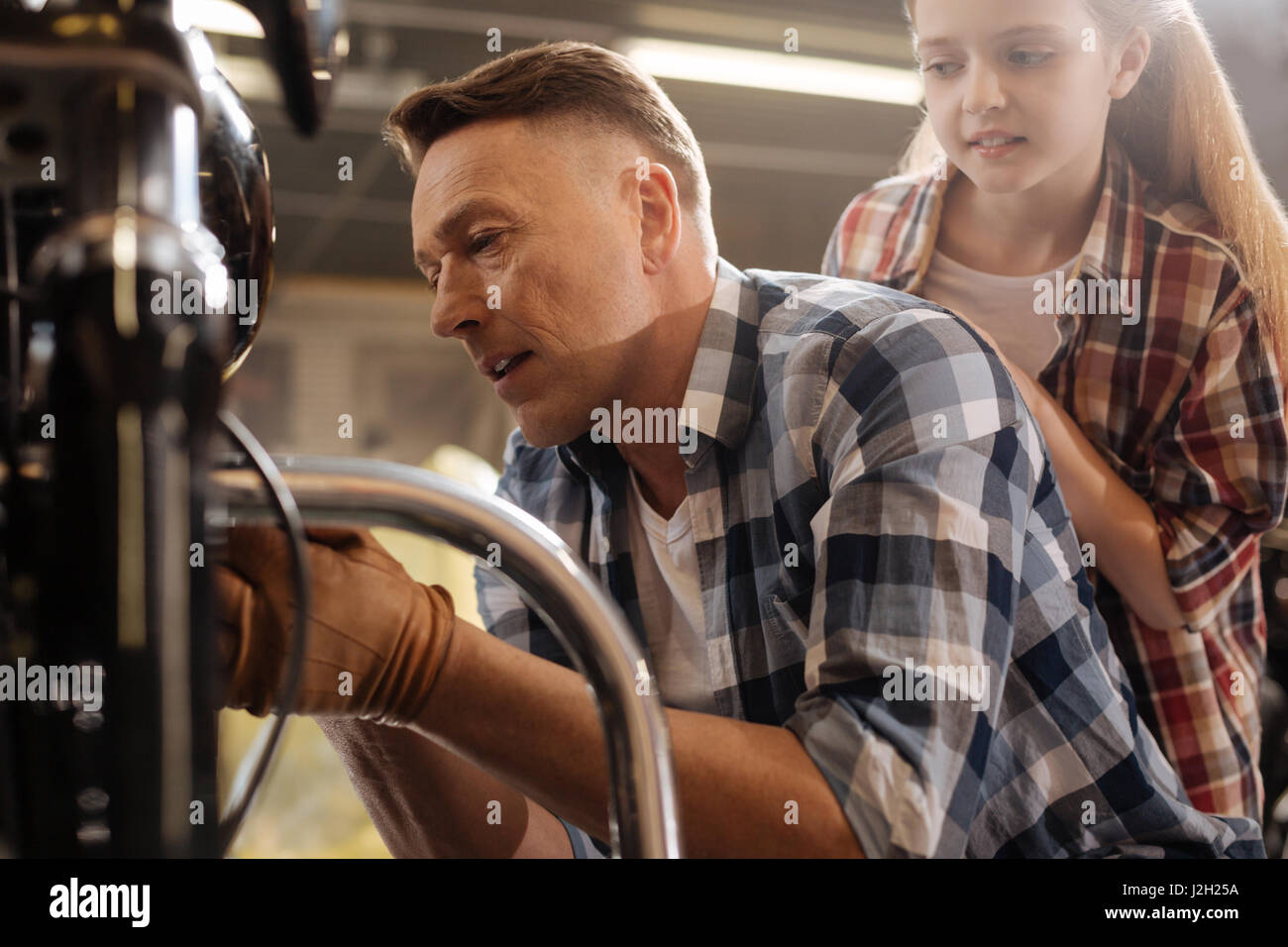 Curious cute child observing her dads work Stock Photo - Alamy
