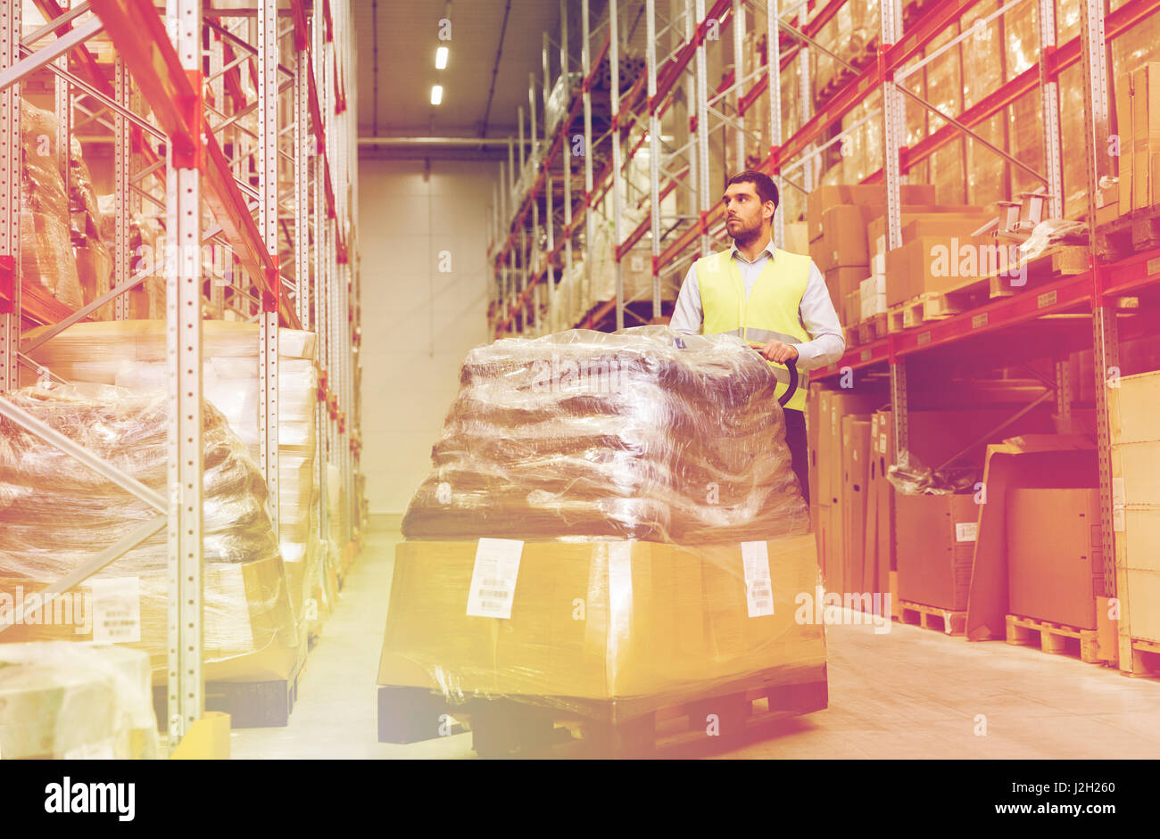 man carrying loader with goods at warehouse Stock Photo - Alamy