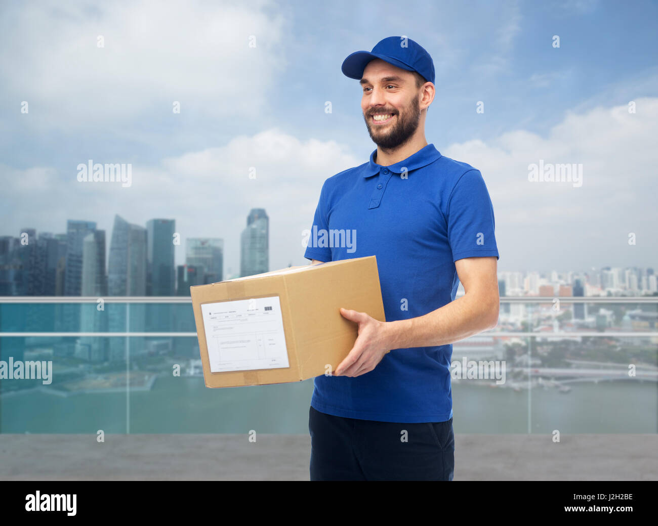 happy delivery man with box over singapore city Stock Photo - Alamy