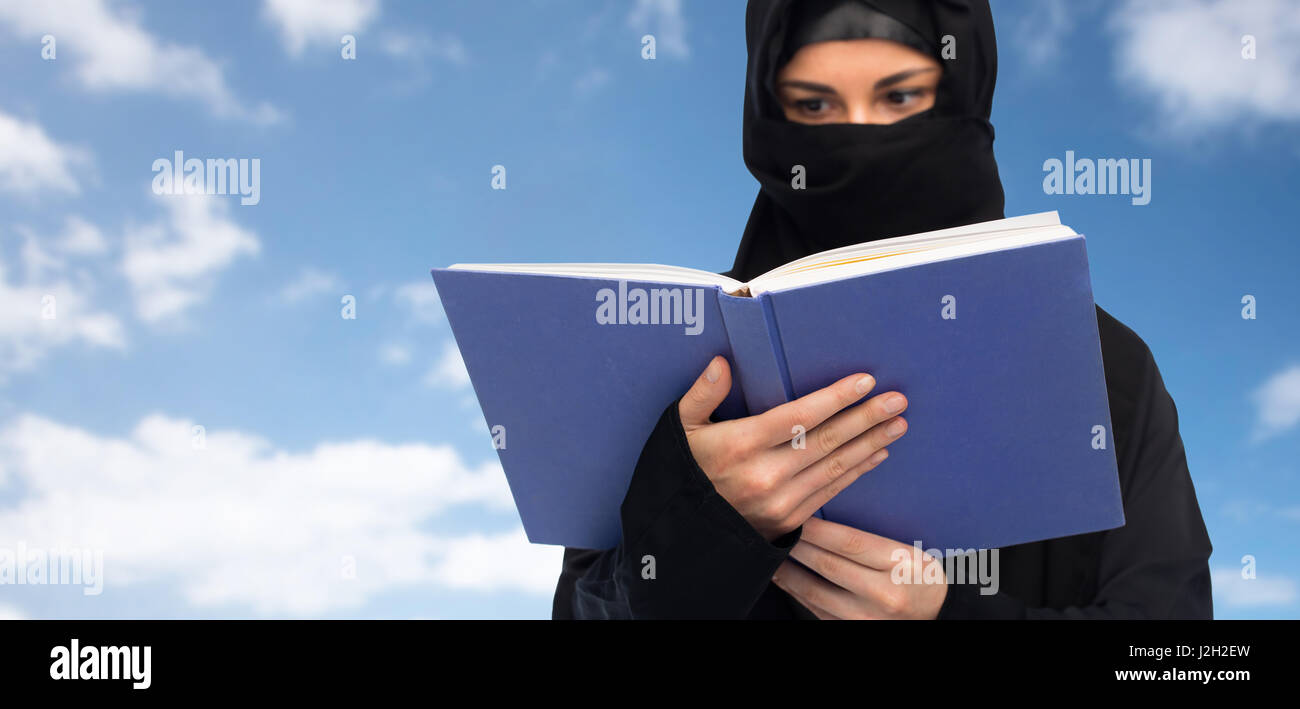 muslim woman in hijab reading book over sky Stock Photo - Alamy