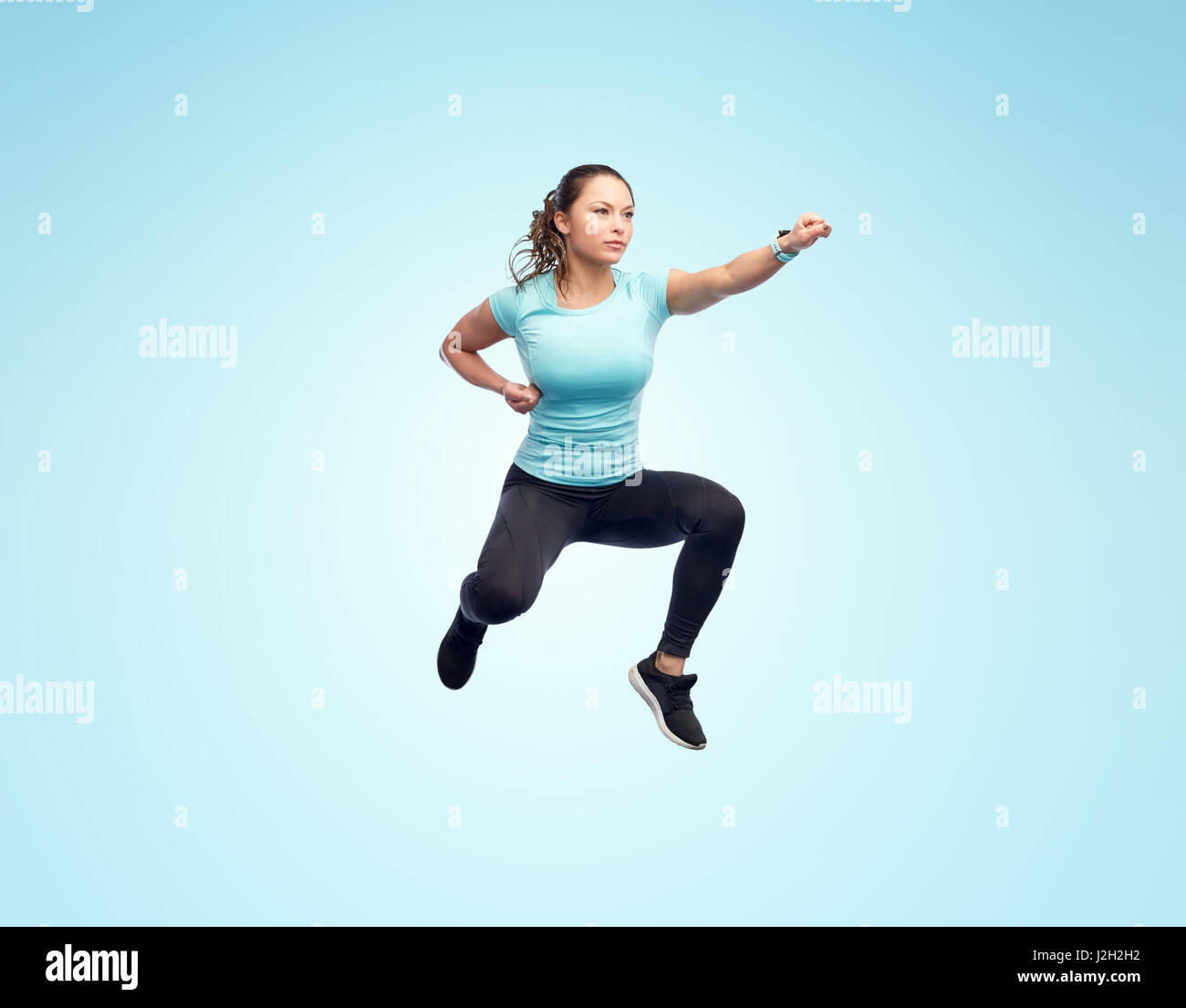 happy sporty young woman jumping in fighting pose Stock Photo - Alamy