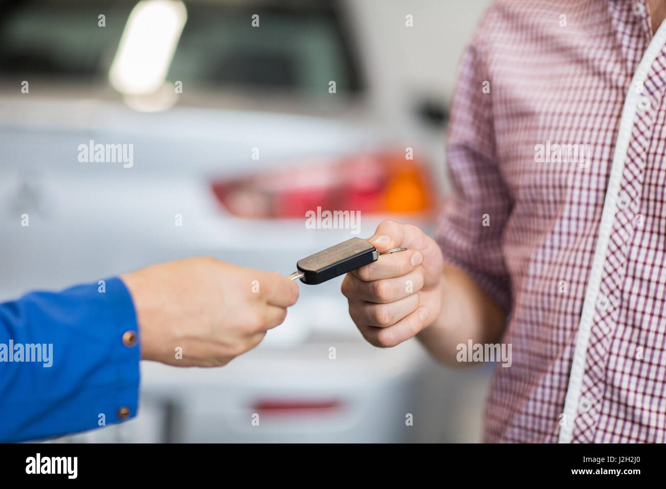 auto mechanic giving car key to man at workshop Stock Photo - Alamy