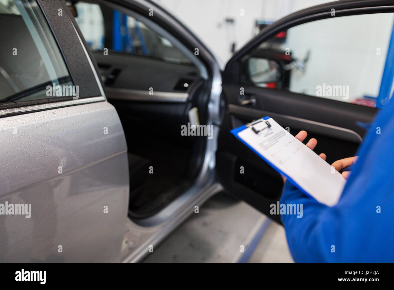 auto mechanic man with clipboard at car workshop Stock Photo - Alamy