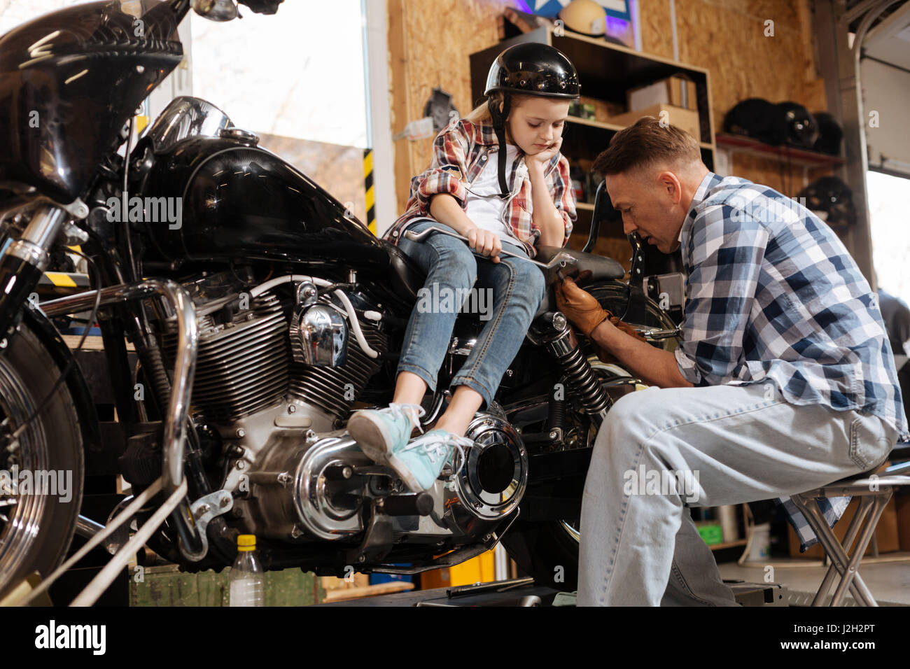 Observant interested girl looking at how her dad fixing things Stock ...
