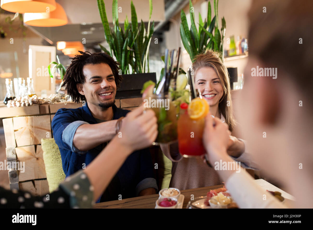 happy friends clinking drinks at restaurant Stock Photo - Alamy