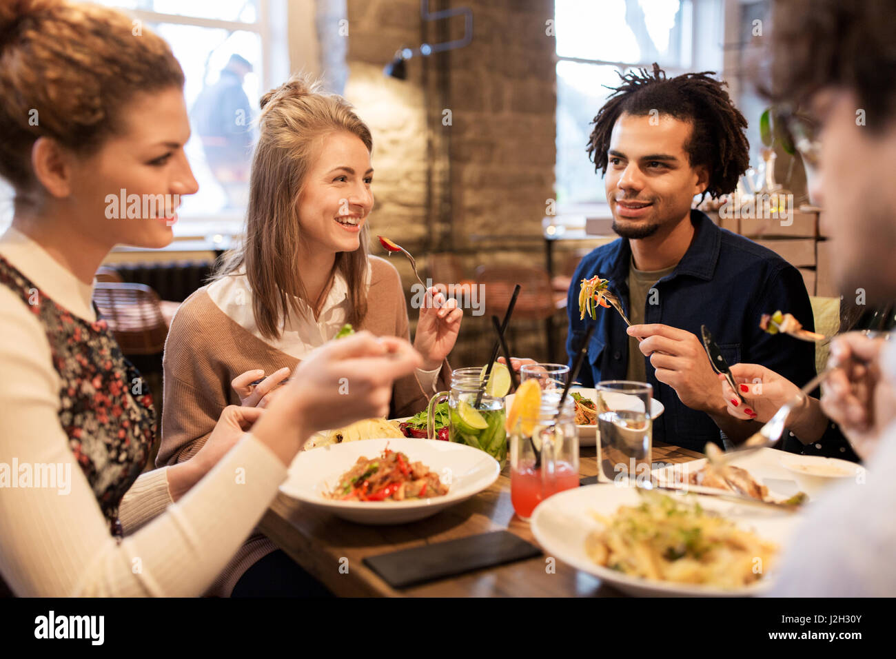 happy friends eating and drinking at restaurant Stock Photo - Alamy