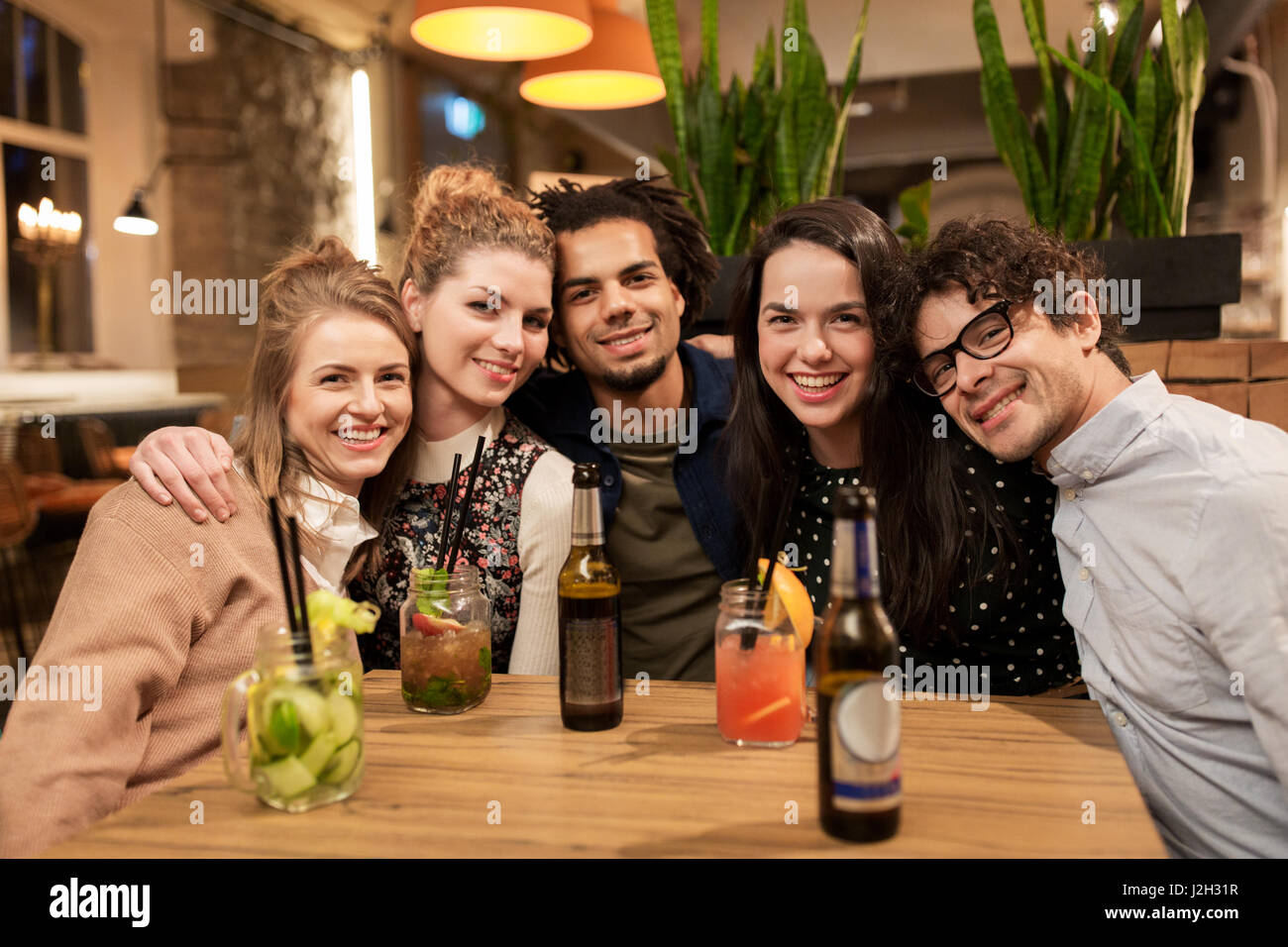 happy friends with drinks at bar or cafe Stock Photo - Alamy