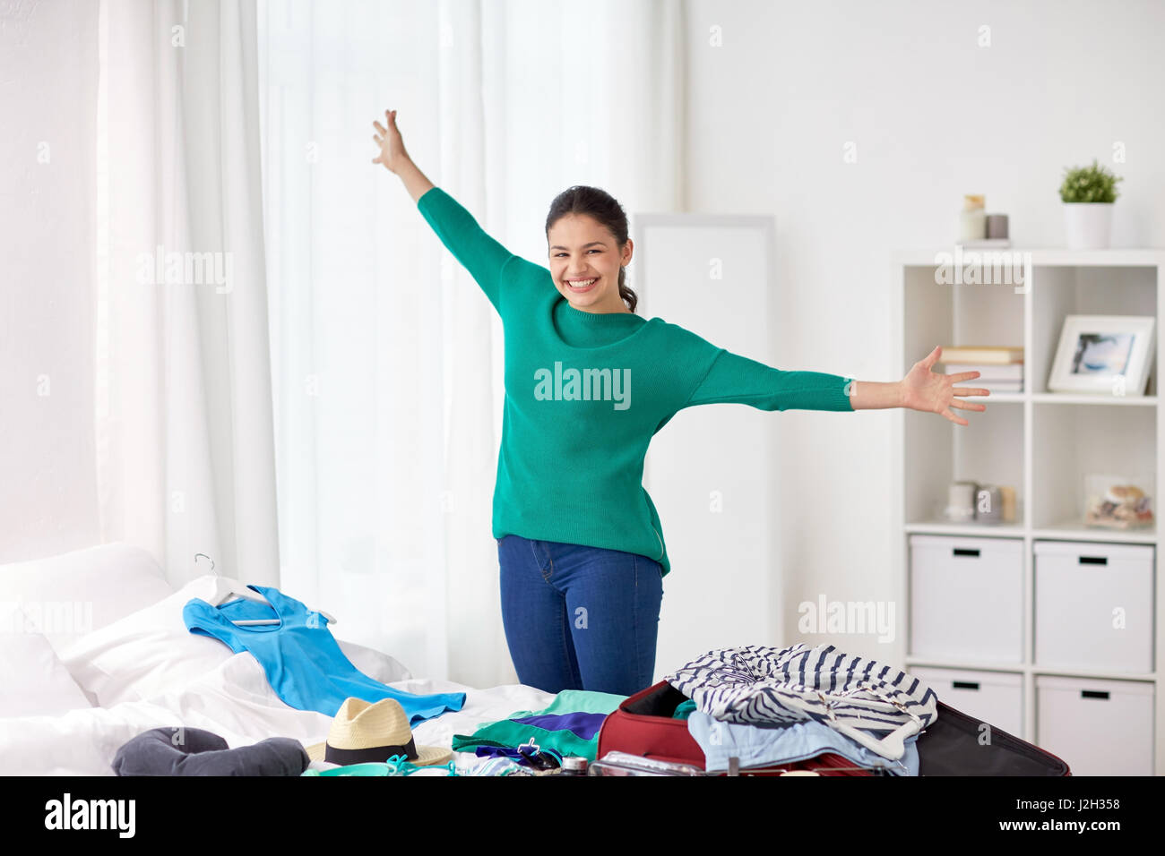 happy woman packing travel bag at home Stock Photo - Alamy