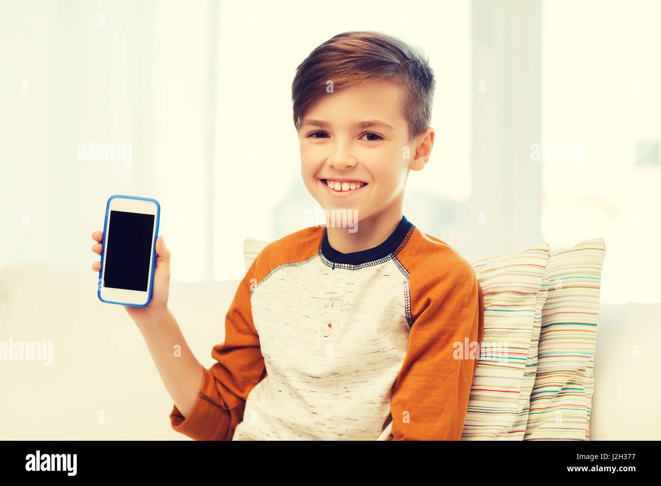 smiling boy with smartphone at home Stock Photo - Alamy