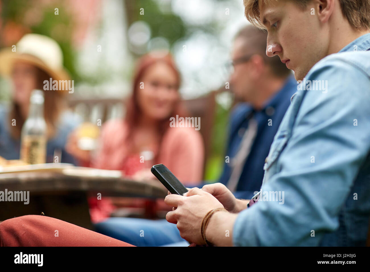 man with smartphone and friends at summer party Stock Photo - Alamy
