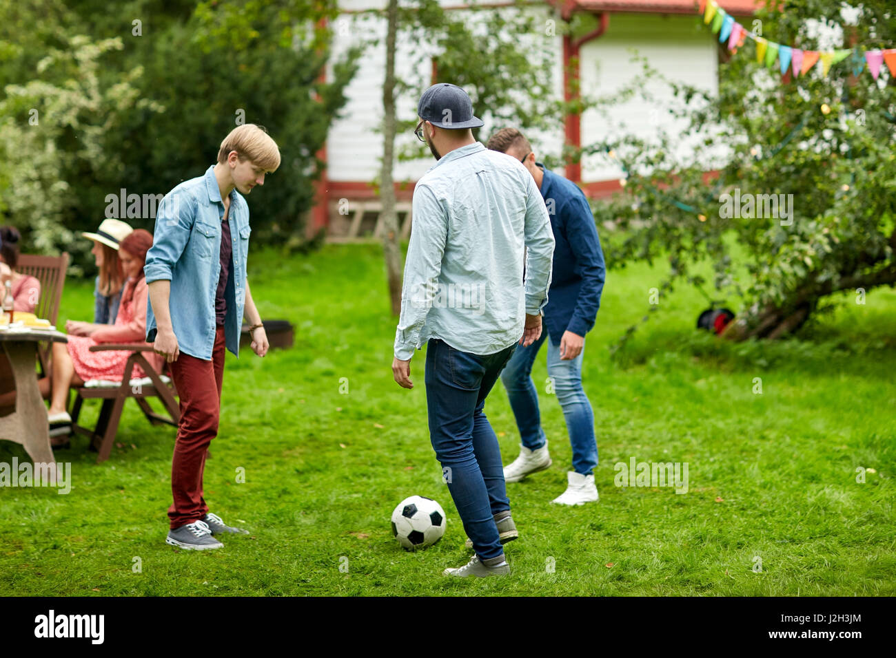 happy friends playing football at summer garden Stock Photo - Alamy