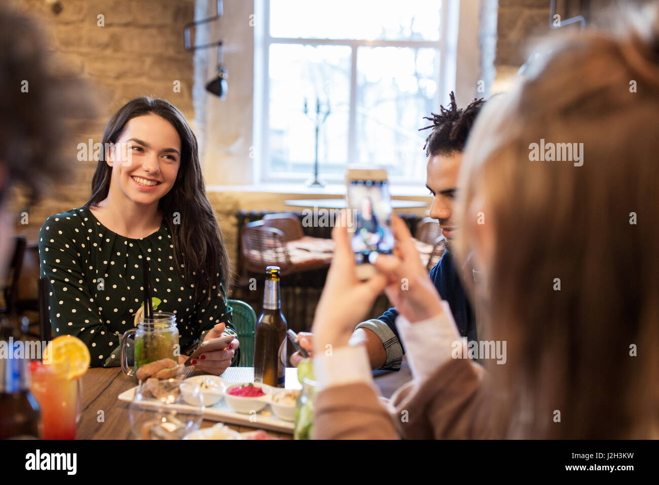 friends with smartphone photographing at cafe Stock Photo - Alamy