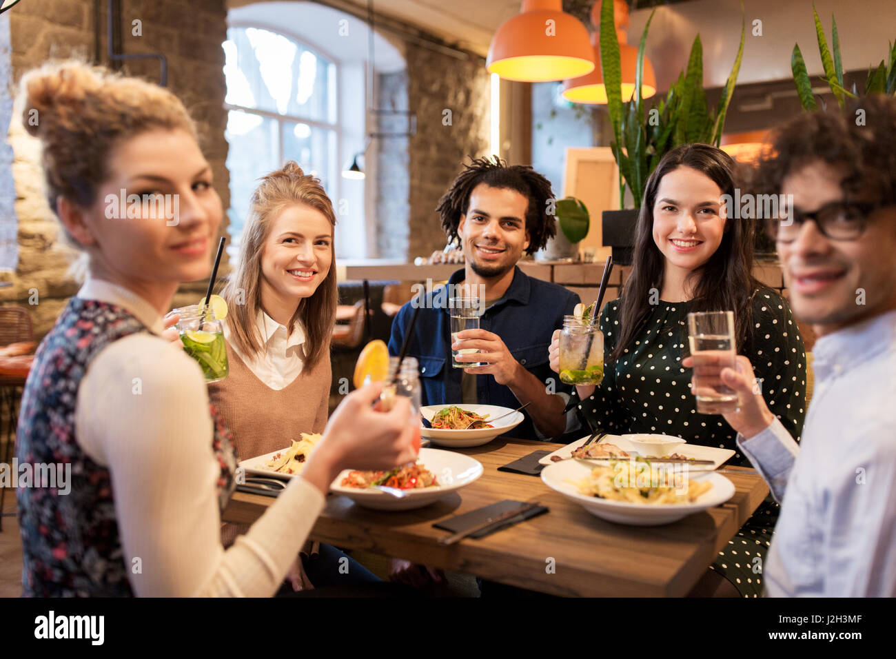 happy friends eating and drinking at restaurant Stock Photo - Alamy