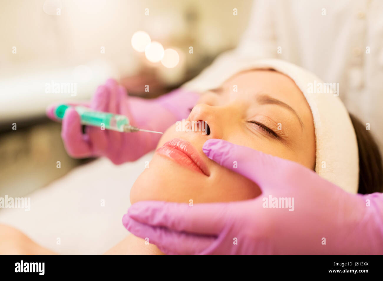 beautician doing beauty injection to woman lips Stock Photo - Alamy
