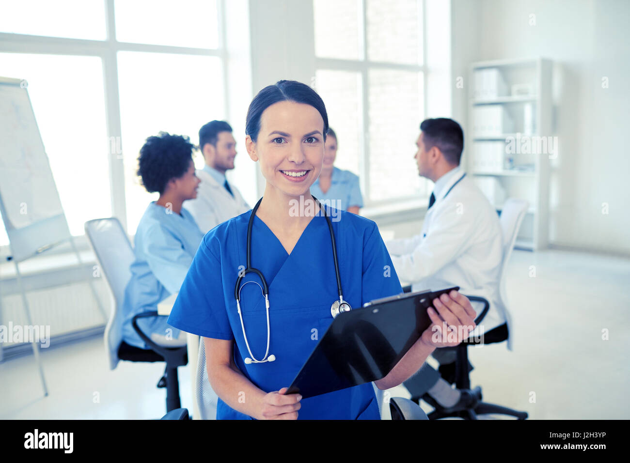 happy doctor with clipboard over group of medics Stock Photo - Alamy