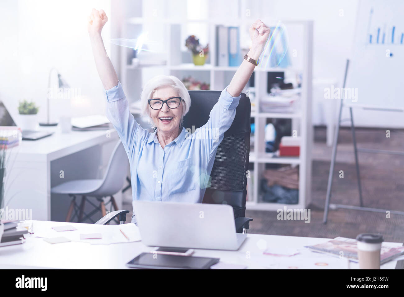 Happy office worker rising her fists up Stock Photo - Alamy
